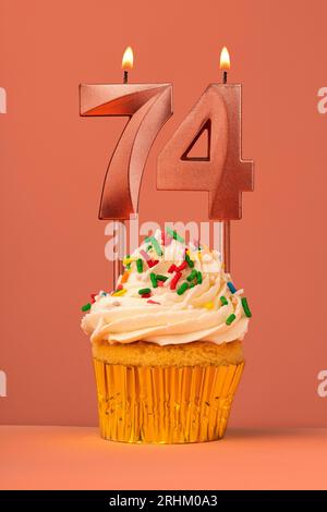 Candle number 74 - Cake birthday in blue background Stock Photo - Alamy