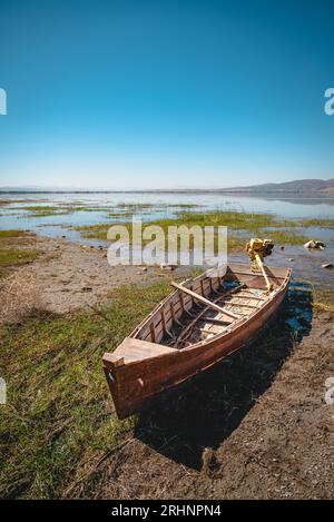 Abandoned row boat on cracked soil on lake bed dried up due to global ...