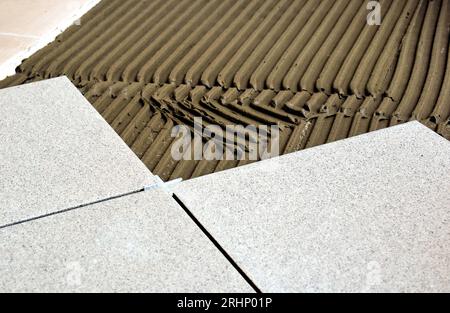 Laying a vinyl tile floor, tiling the edge, using craft knife and ruler ...