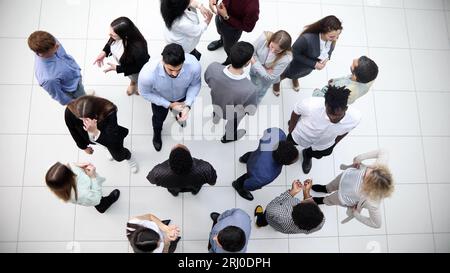 office workers and foreign employees stand and talk in the office lobby ...