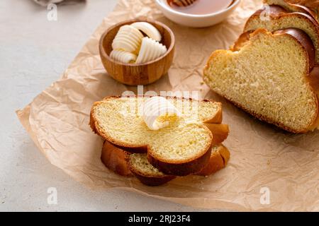 Freshly baked hallah sliced served with butter and honey, overhead shot ...