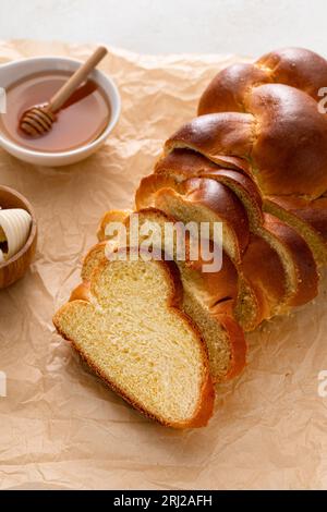 Freshly baked hallah sliced served with butter and honey, overhead shot ...
