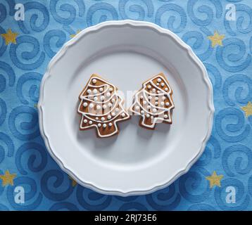 Plate in shape of Christmas tree with treats, decor and fir branches on ...