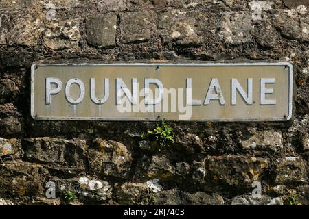 Sreet sign for Pound Lane against a stone wall. Caerwent village, South ...
