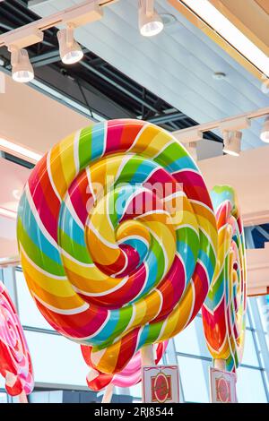 Bright rainbow lollipop candy on colorful yellow wood table for ...