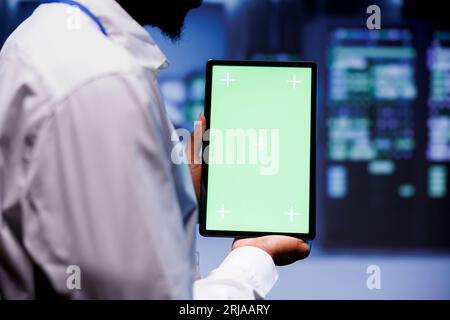 Admin in data center with chroma key tablet using artificial intelligence computing simulating ...