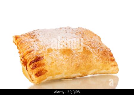 One aromatic puff pastry bun with apples cut in half, macro, isolated ...