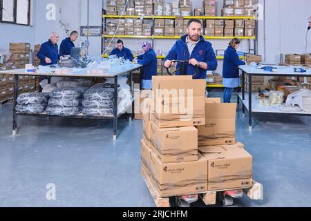 people working in a sticker printing factory. worker uses a stickier ...
