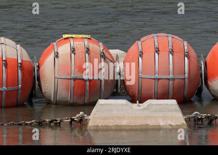 Workmen reposition a 1000-foot long string of buoys in a shallow spot ...