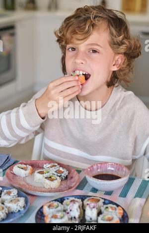 Cute kid boy eating sushi in asian restaurant Stock Photo - Alamy