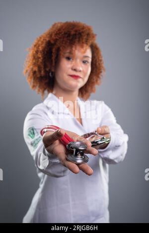 Young redhead doctor woman showing smartphone doing ok sign with ...