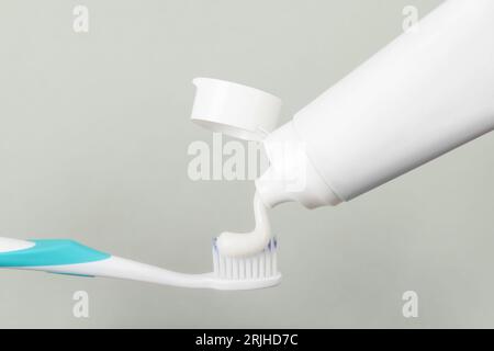 Applying paste on toothbrush against white background Stock Photo - Alamy