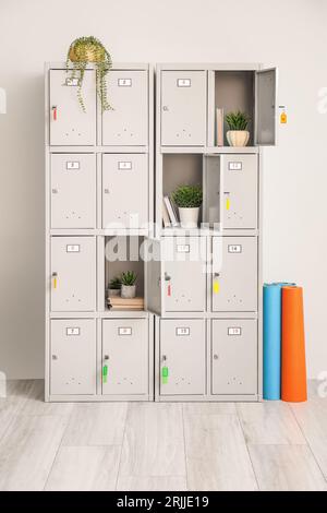 Modern locker with books and plants near pink wall Stock Photo - Alamy