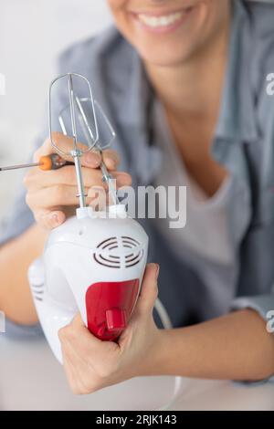 handsome man holding screwdriver and using laptop Stock Photo - Alamy