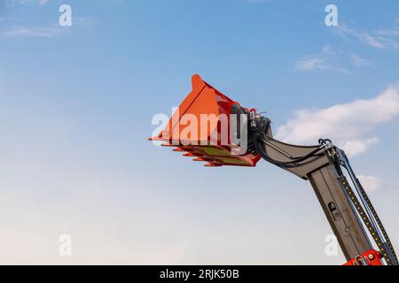 Raised excavator bucket against the blue sky. Copy space Stock Photo ...