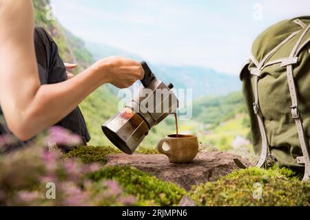 Woman tourist backpacker pouring coffee from a moka coffee maker into a ...
