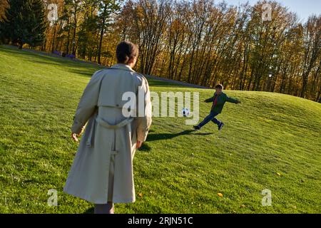 Cute African-American boy with autumn leaves on orange background with ...