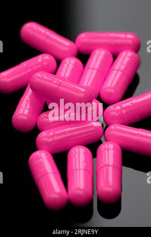Medicines. Pink pharmaceutical capsules with tablets are in the ...