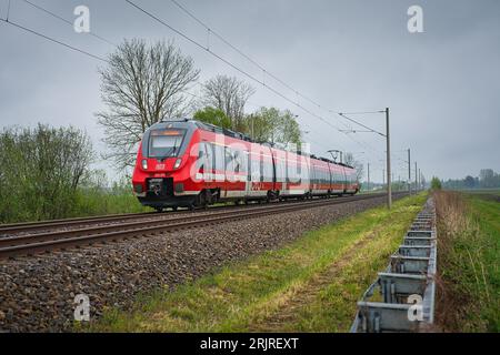 A passenger train chugging along the tracks in a rural setting with ...