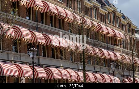 The red striped canvas canopies over rows of window Stock Photo - Alamy