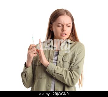Young female junkie rejecting syringe with drugs on white background ...