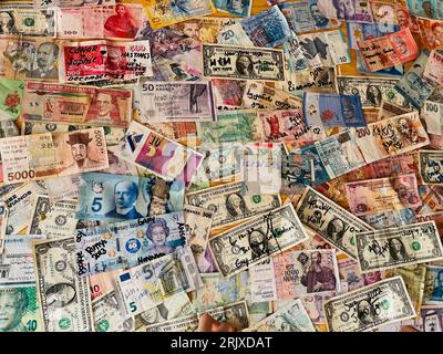 Collection of paper currency from around the world pinned to a bulletin ...