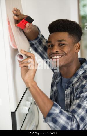handyman applying blue for a wallpaper Stock Photo - Alamy