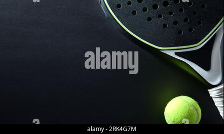 Detailed background of black and white padel racket and ball on black ...