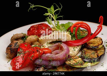 Grilled vegetables with cheese, mushrooms and spices on a plate Stock ...