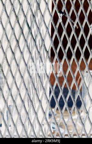 A typical metal chain link fence with a repeating pattern of steel ...