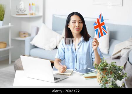 Beautiful Asian woman with UK flag learning English language online at ...
