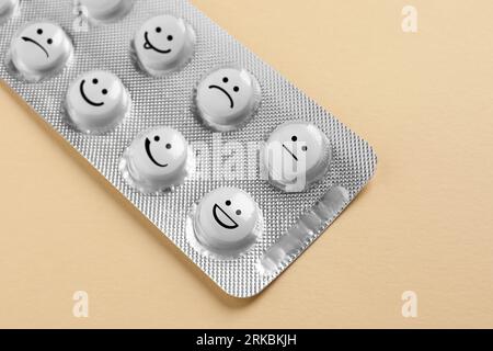 Pills with different emotional faces in blister on light blue ...