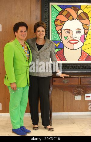 Brazilian artist Romero Britto poses for photos next to his sculpture ...