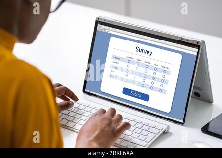 African Woman Filling Online Survey Form On Laptop Computer Stock Photo ...