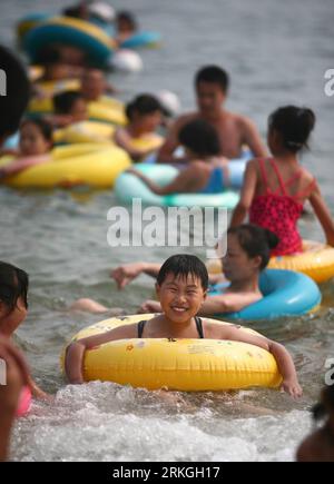 Tourists play at a bathing beach in Rizhao City, east China's Shandong ...