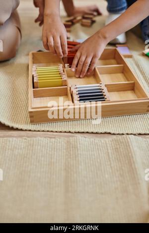 montessori concept, cropped view of girl writing on chalkboard, holding ...