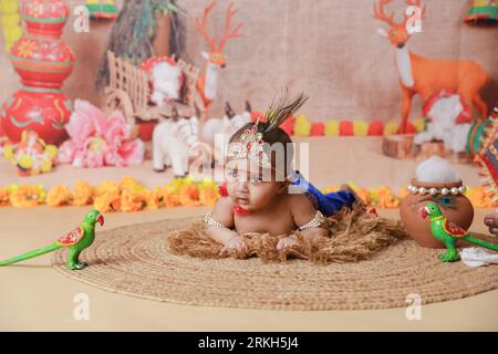 A child dressed up as lord Krishna and standing on a five headed cobra ...