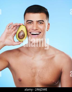 Studio, portrait and man with avocado, skincare and smile with ...