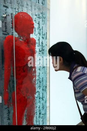 A visitor looks at a plastinated human body during the "Bodies 2.0: The ...