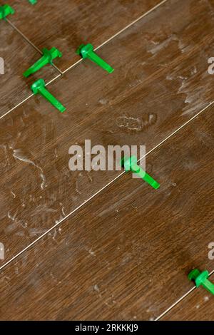 Tile levelling system, four plastic green clips with wedges. Close-up ...