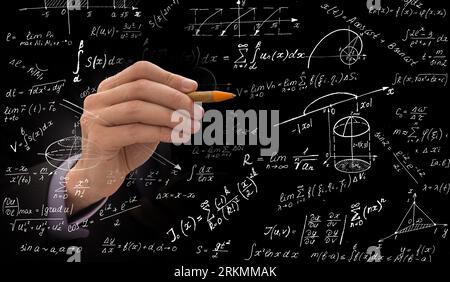 Male hand writing mathematical formulas on blurry background. Science ...