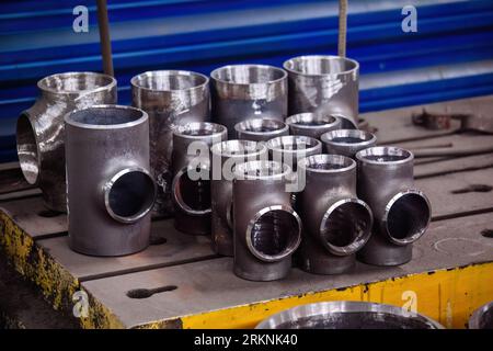 Batch of T shape pipe parts in factory Stock Photo - Alamy
