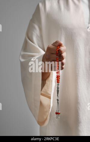 Hand with tasbih and Koran on beige background. Greeting card for ...