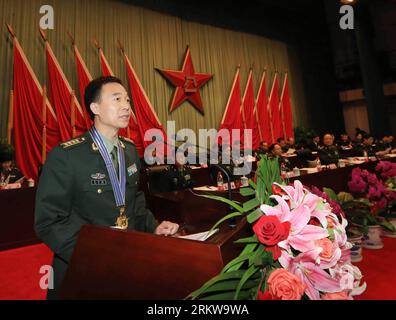 Chinese astronaut Jing Haipeng speaks from behind a glass enclosure ...