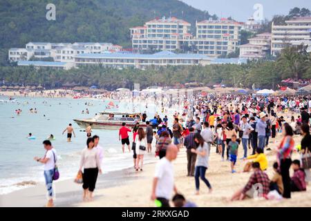 Tourists play at the seaside in Sanya City, southernmost China's Hainan ...