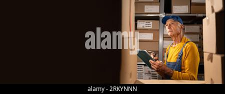The elderly male inventory manager checks stock using a clipboard. Old ...