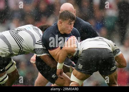 England's Theo Dan, centre, is tackled by Fiji's Lekima Tagitagivalu ...