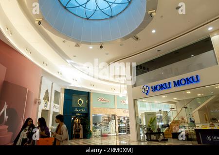 Moda Mall - Bahrain. Women shopping passing Louis Vuitton boutique ...