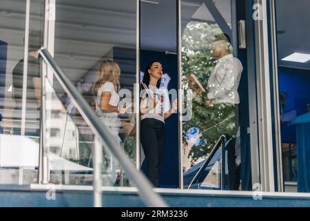 A group of students exiting their college with their notebooks in their ...