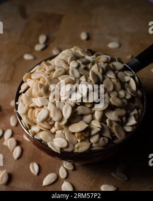 overhead view of nigerian egusi seeds in a brown bowl, shelled melon ...